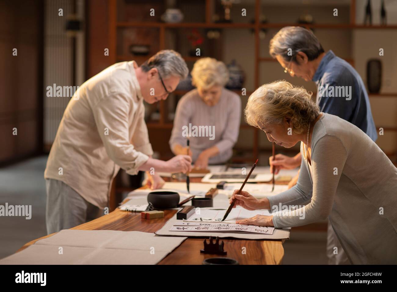 Happy friends practicing calligraphy together Stock Photo - Alamy