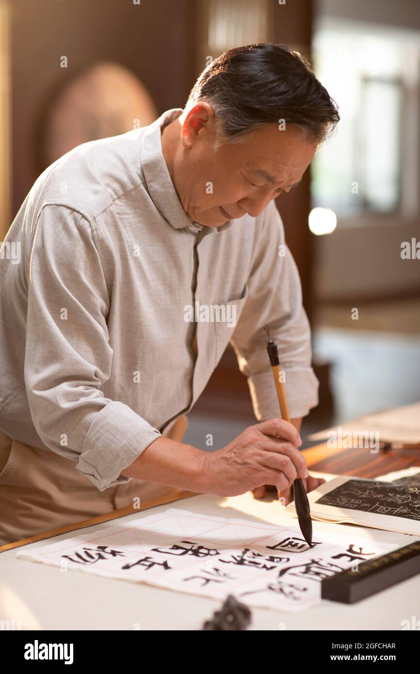 Senior man practicing calligraphy in the study Stock Photo - Alamy