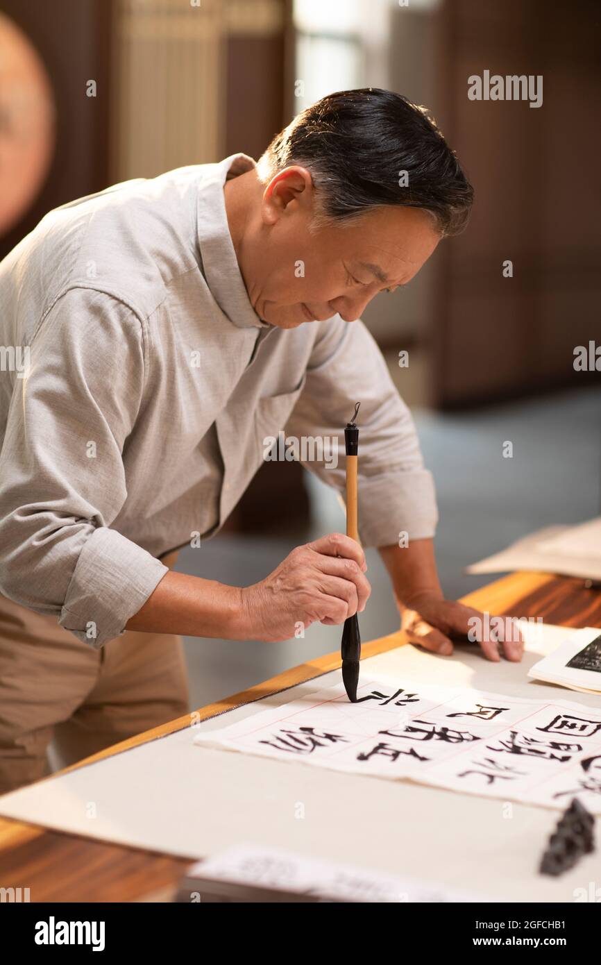 Senior man practicing calligraphy in the study Stock Photo - Alamy