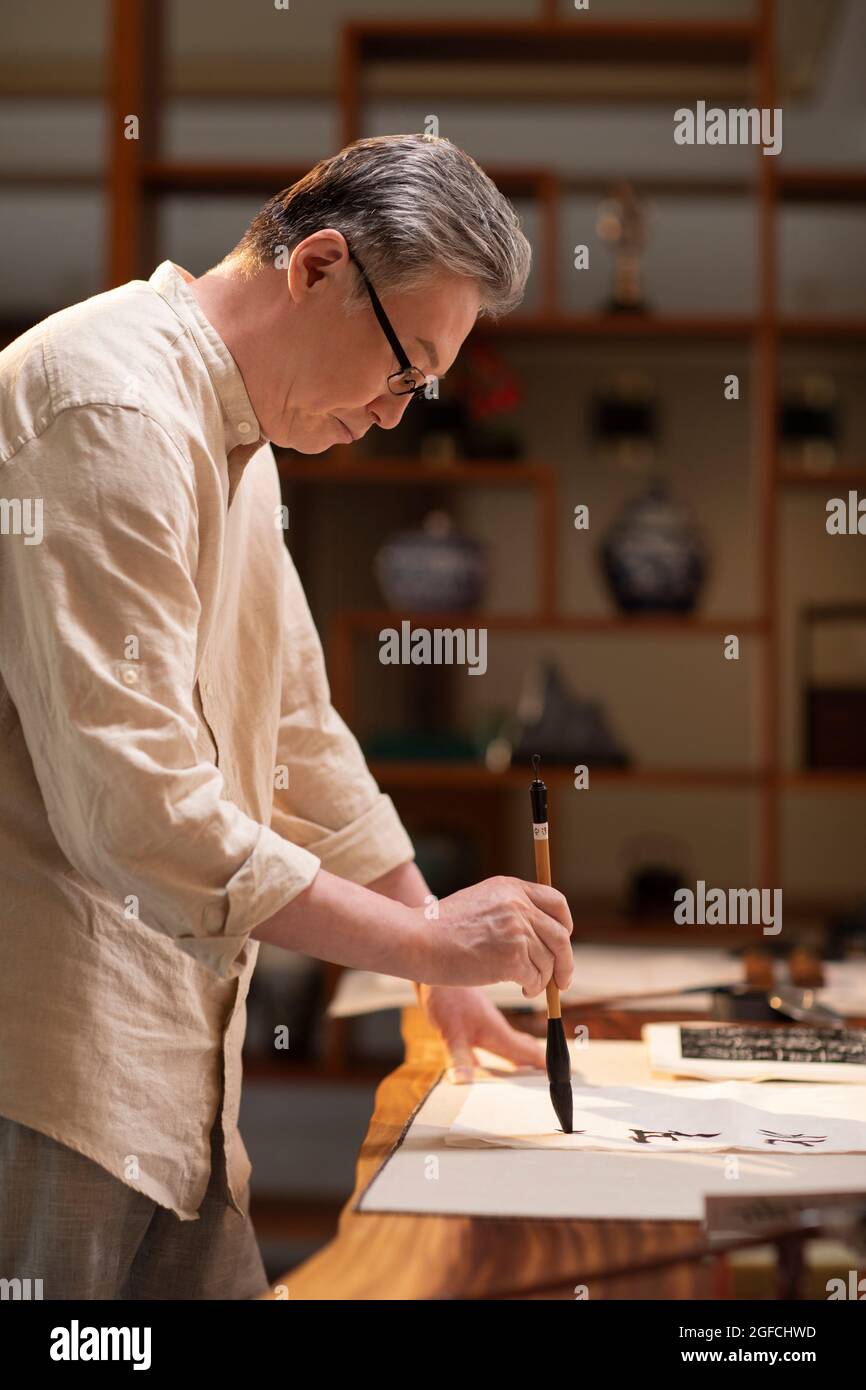 Senior man practicing calligraphy in the study Stock Photo - Alamy