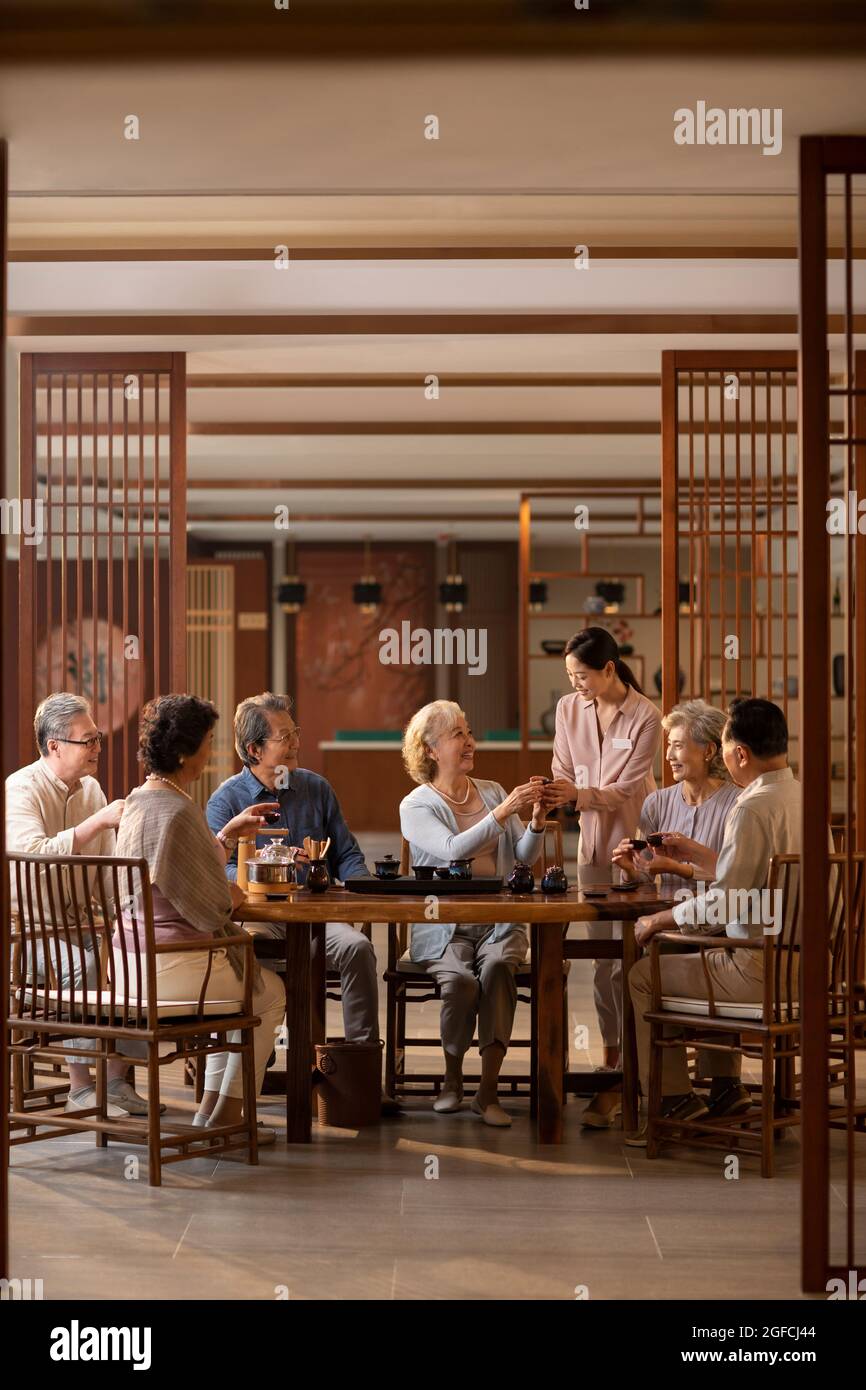 Happy friends drinking tea together Stock Photo - Alamy