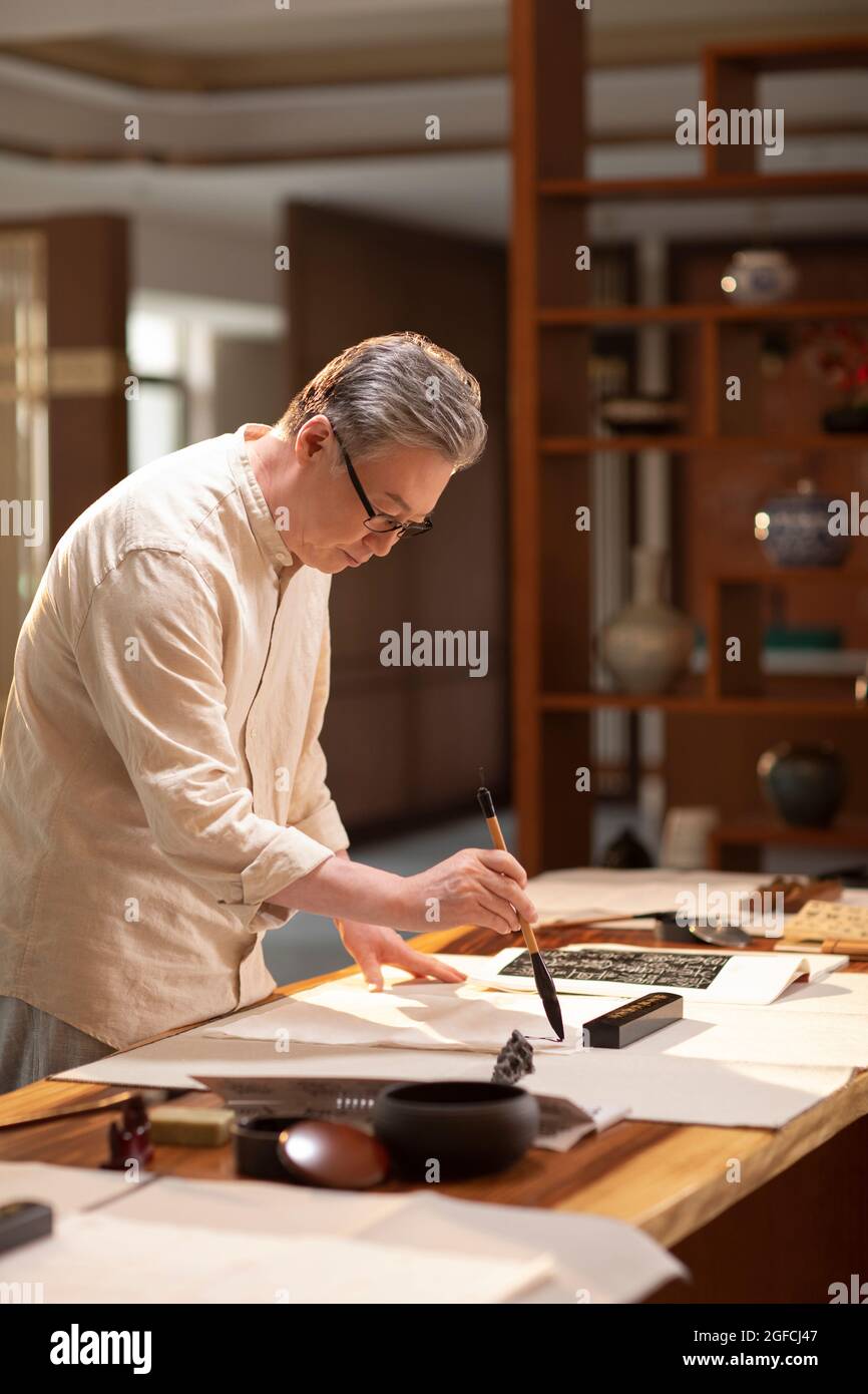 Senior man practicing calligraphy in the study Stock Photo - Alamy
