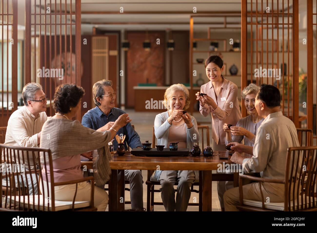 Happy friends drinking tea together Stock Photo - Alamy