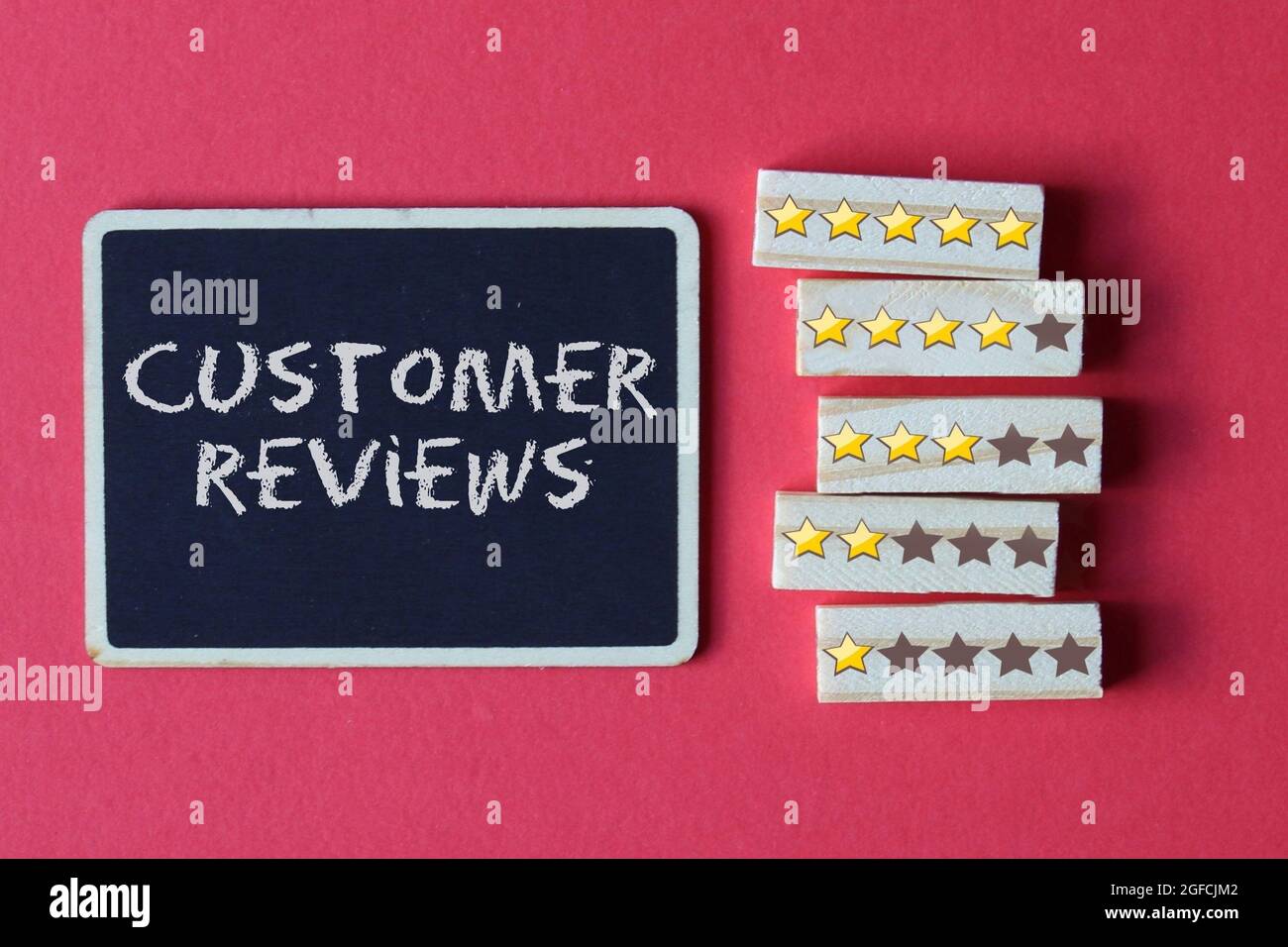 Top view of black board with text CUSTOMER REVIEWS and wooden tiles ...
