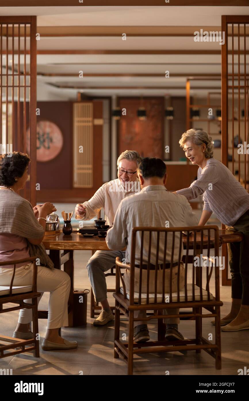 Happy friends drinking tea together Stock Photo - Alamy
