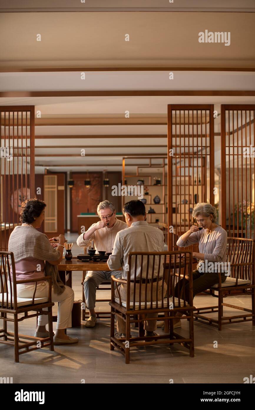 Happy friends drinking tea together Stock Photo - Alamy
