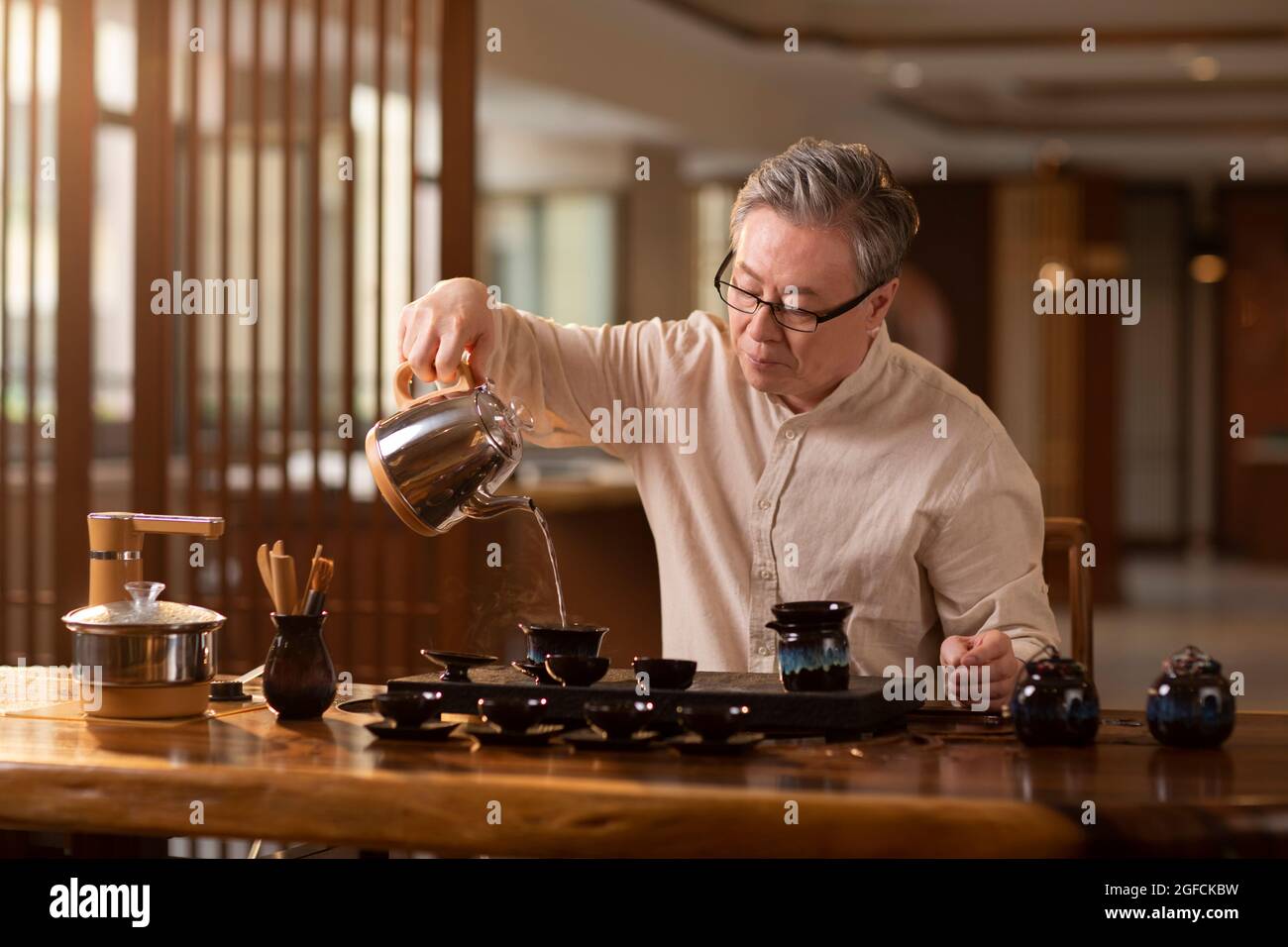 Senior man pouring tea cup hi-res stock photography and images - Alamy
