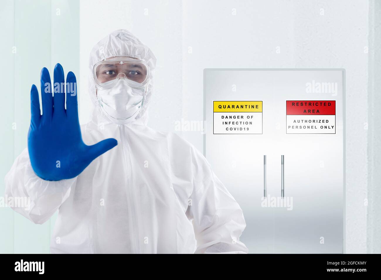 Health worker man with a protective suit and gloves standing with a ...