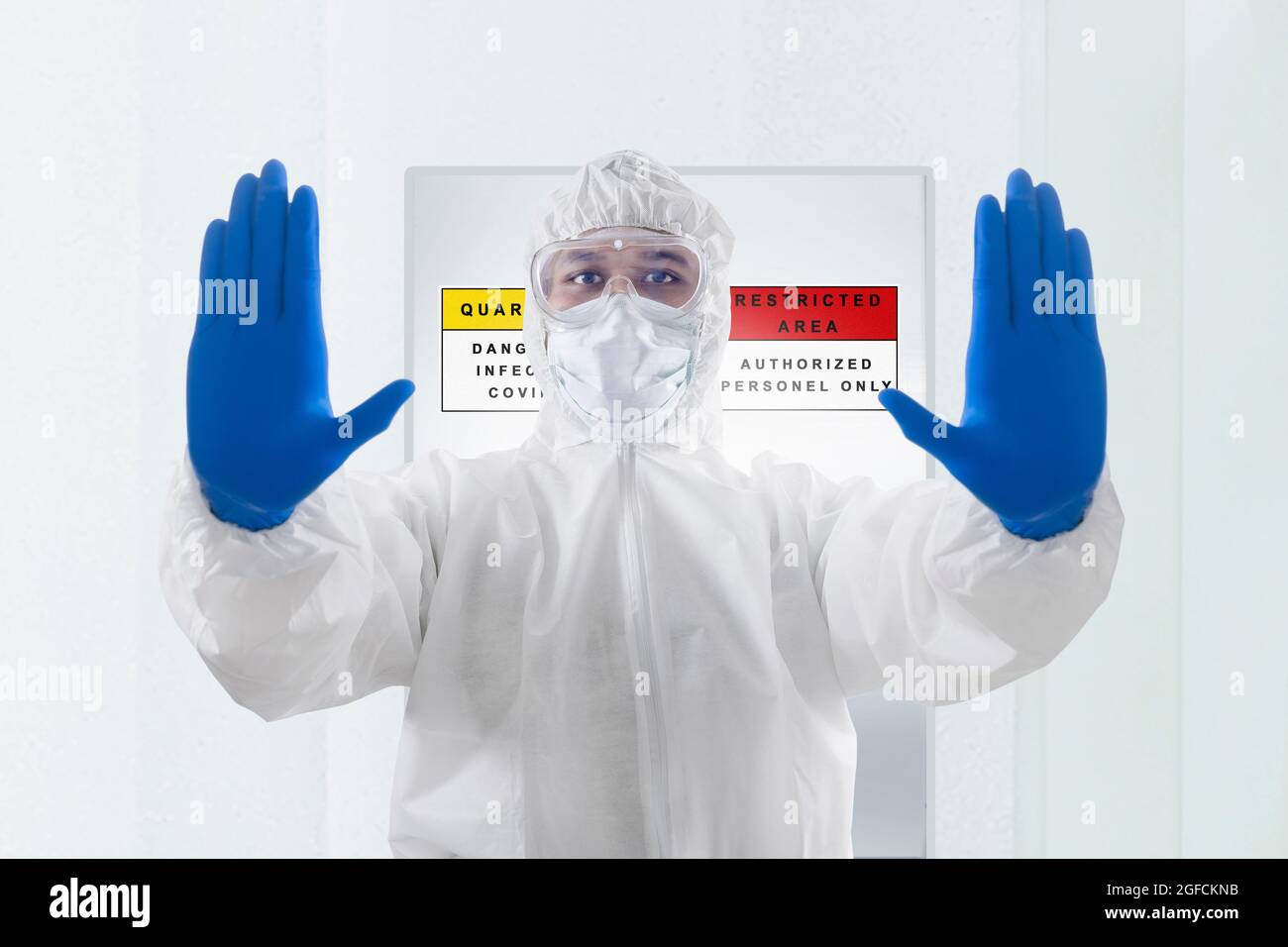 Health worker man with a protective suit and gloves standing with a ...