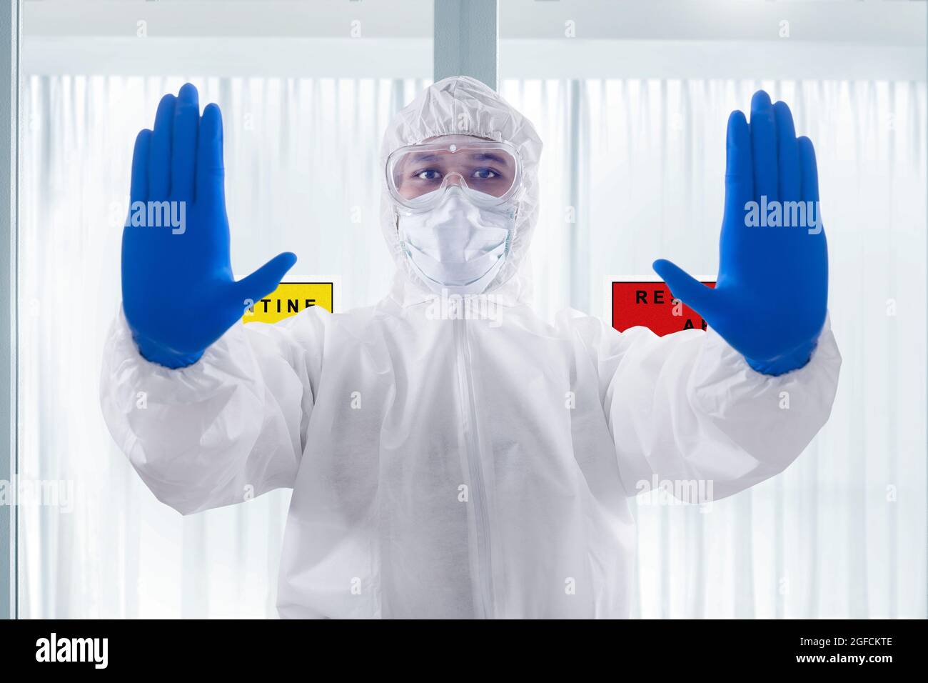 Health worker man with a protective suit and gloves standing with a ...