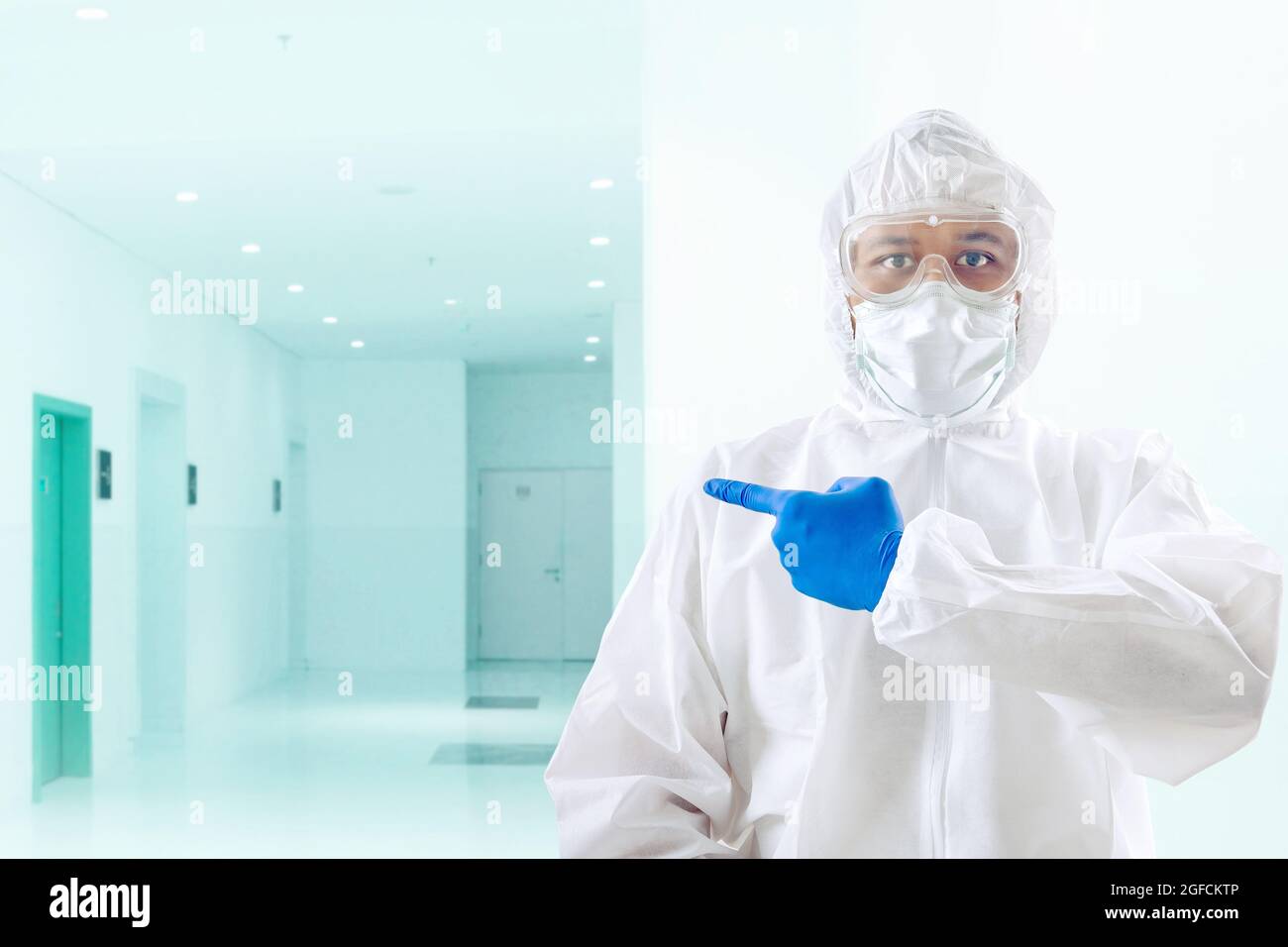 Health worker man with a protective suit and gloves standing with ...