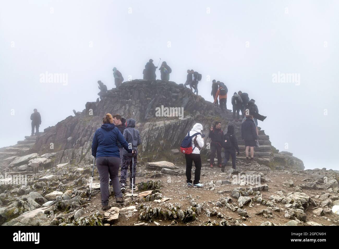 Queue of hikers at the misty Snowdon summit, Snowdonia National PArk ...
