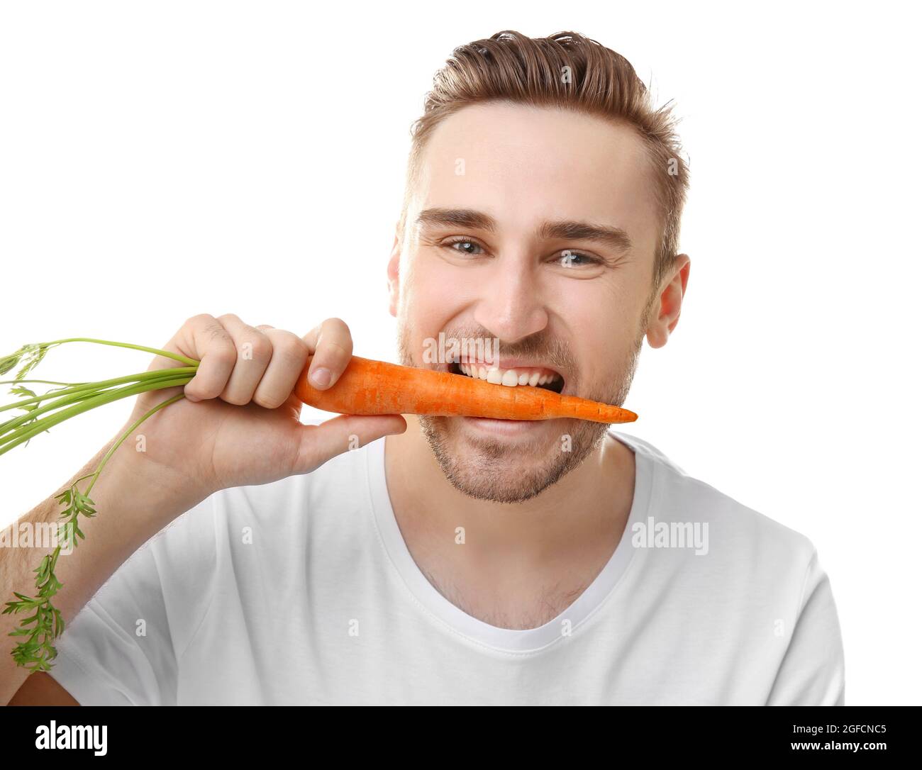 Handsome man eating carrot, isolated on white Stock Photo - Alamy