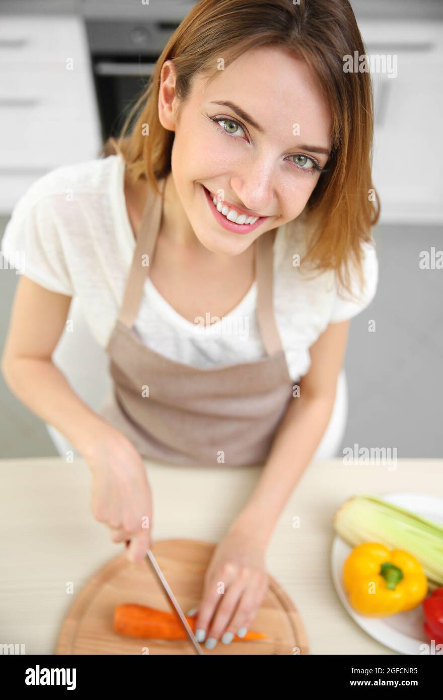 Beautiful girl cutting vegetables in kitchen Stock Photo - Alamy
