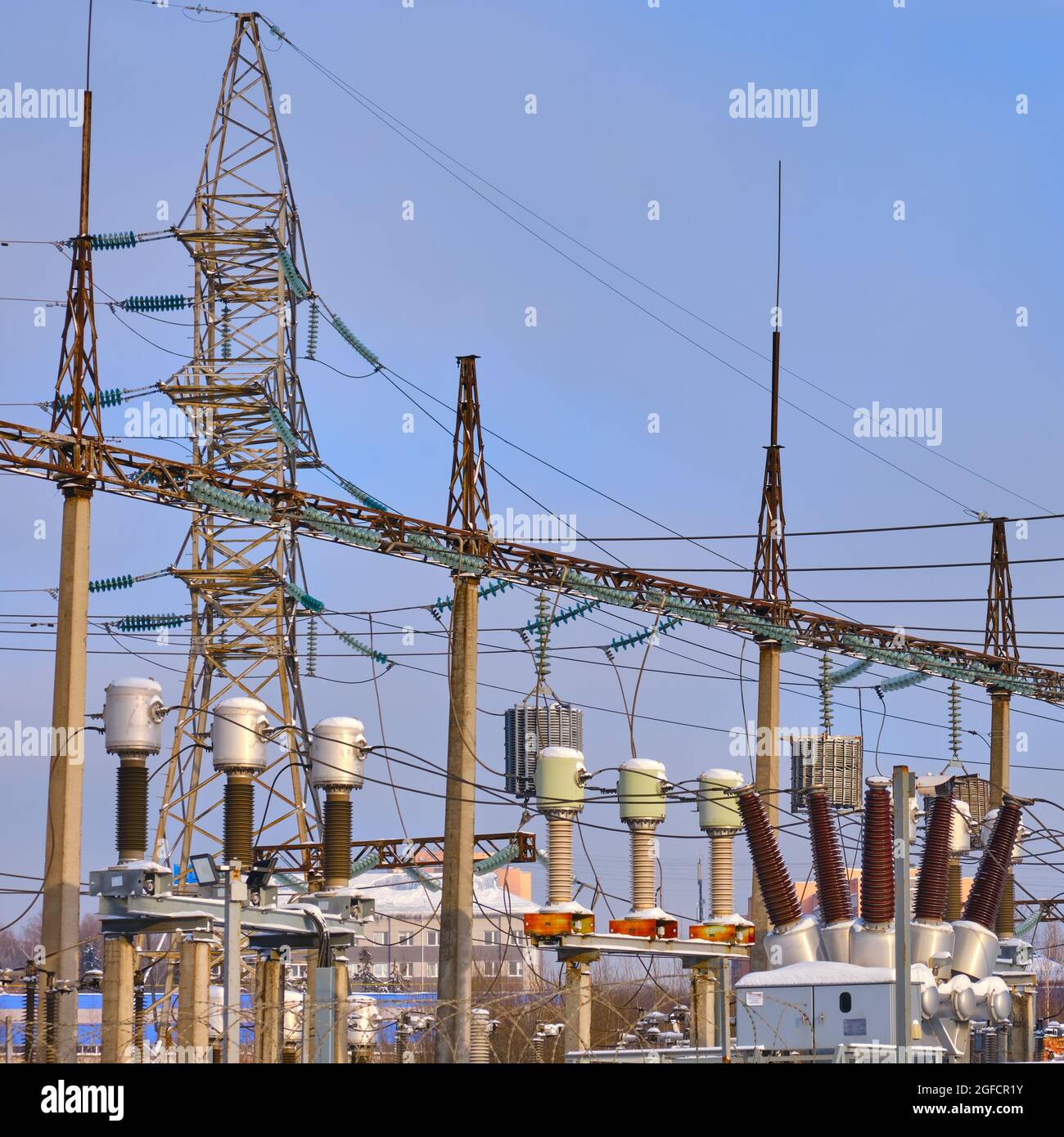 Power plant in winter with electricity transformers covered with snow ...