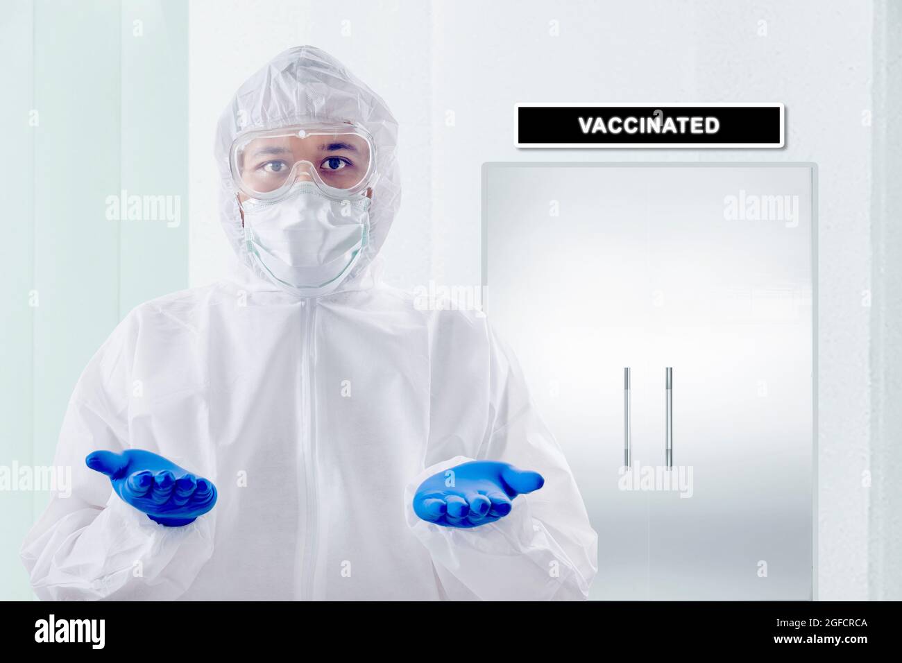 Health worker man with a protective suit and gloves standing with an ...