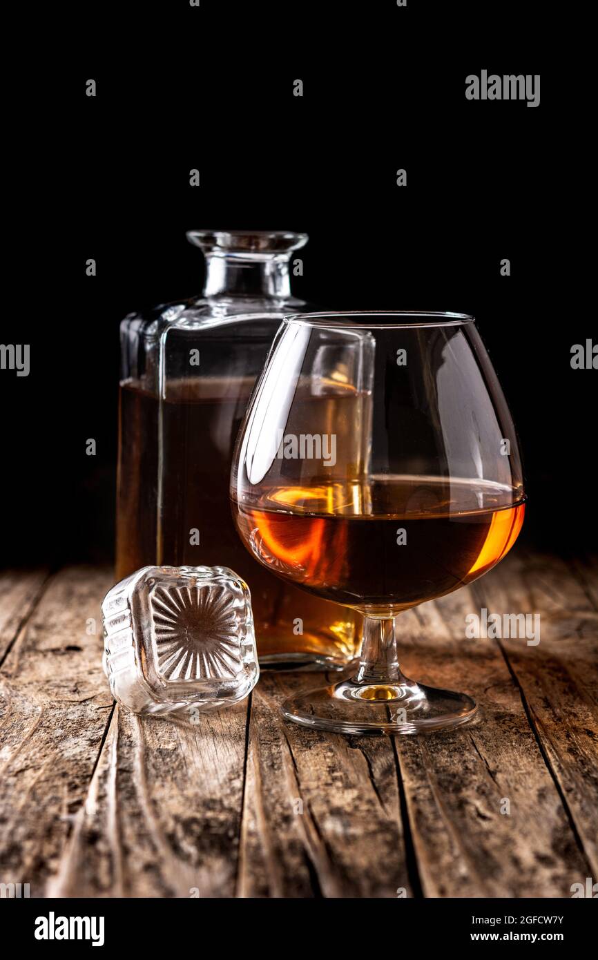 Cognac or whiskey drink on rustic wooden table and black background ...