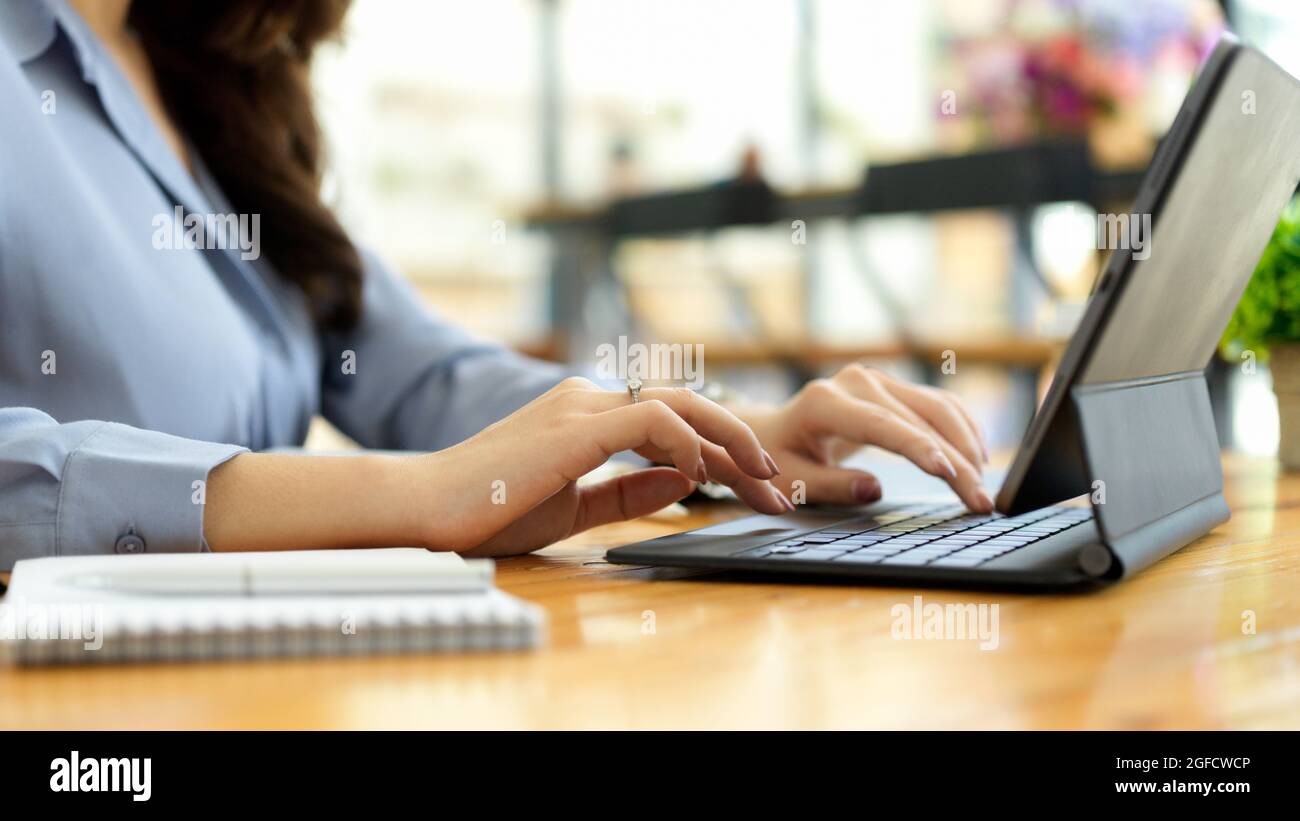 Businesswoman using portable tablet, typing on portable keyboard at ...
