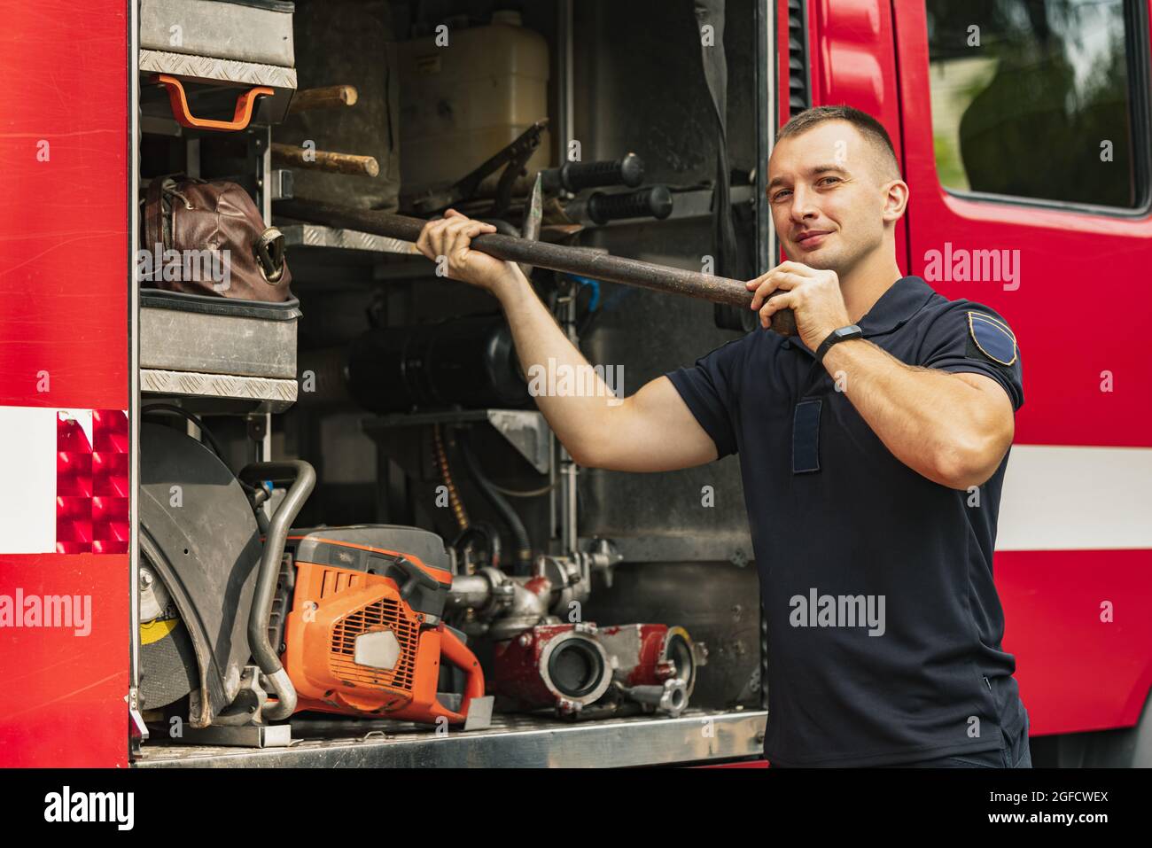 Fireman working in fire truck with special equipment Stock Photo - Alamy