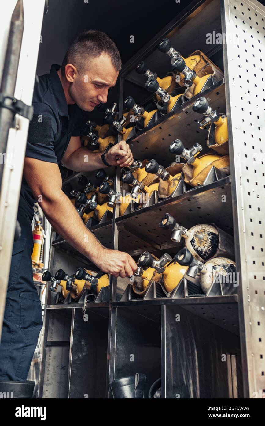 Fireman checking fire extinguisher in truck Stock Photo - Alamy