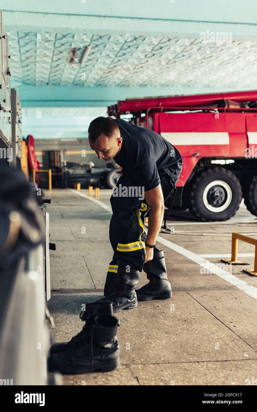 Firefighter wearing uniform in fire station Stock Photo - Alamy
