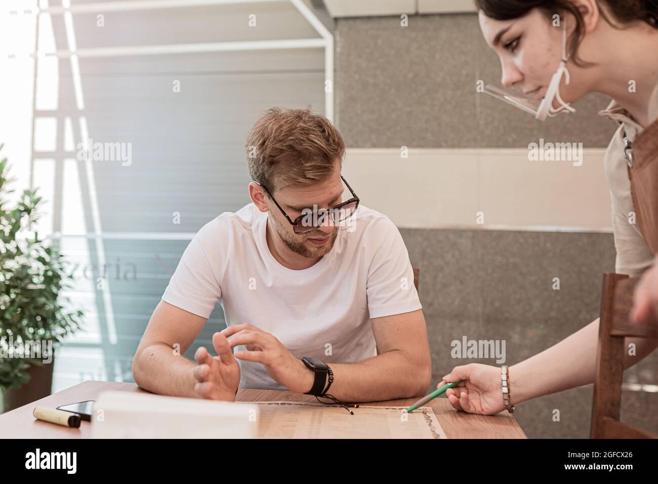 guy with a beard makes an order in restaurant to a waitress in ...
