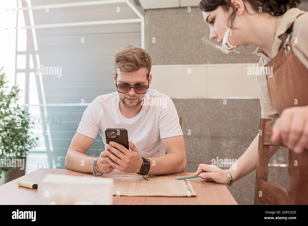guy with a beard makes an order in restaurant to a waitress in ...