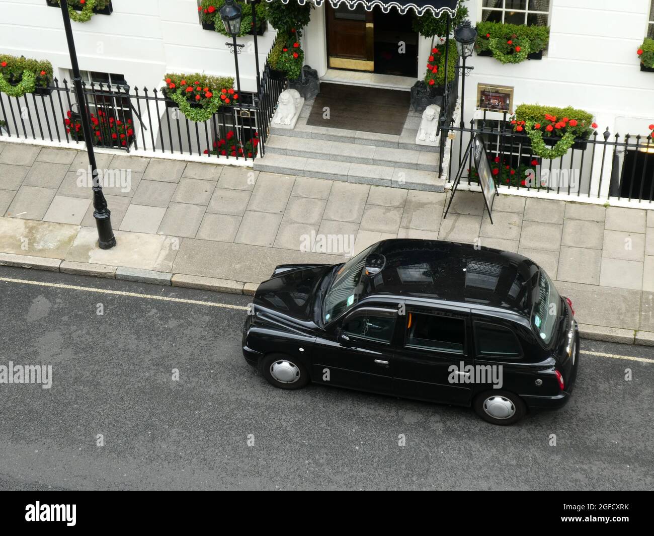 a black cab taxi seen waiting outside a hotel in London Stock Photo - Alamy
