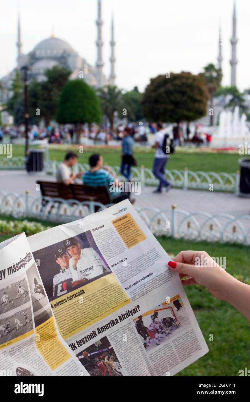 Istanbul, Turkey - June 8, 2014: A woman reading a newspaper with the ...