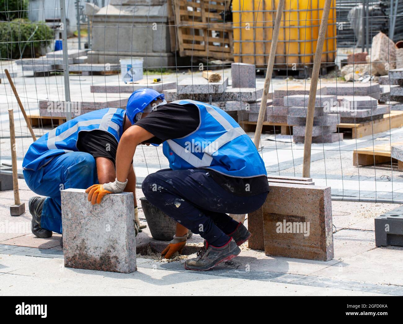 road workers in blue uniforms and helmets on the pavement Stock Photo ...