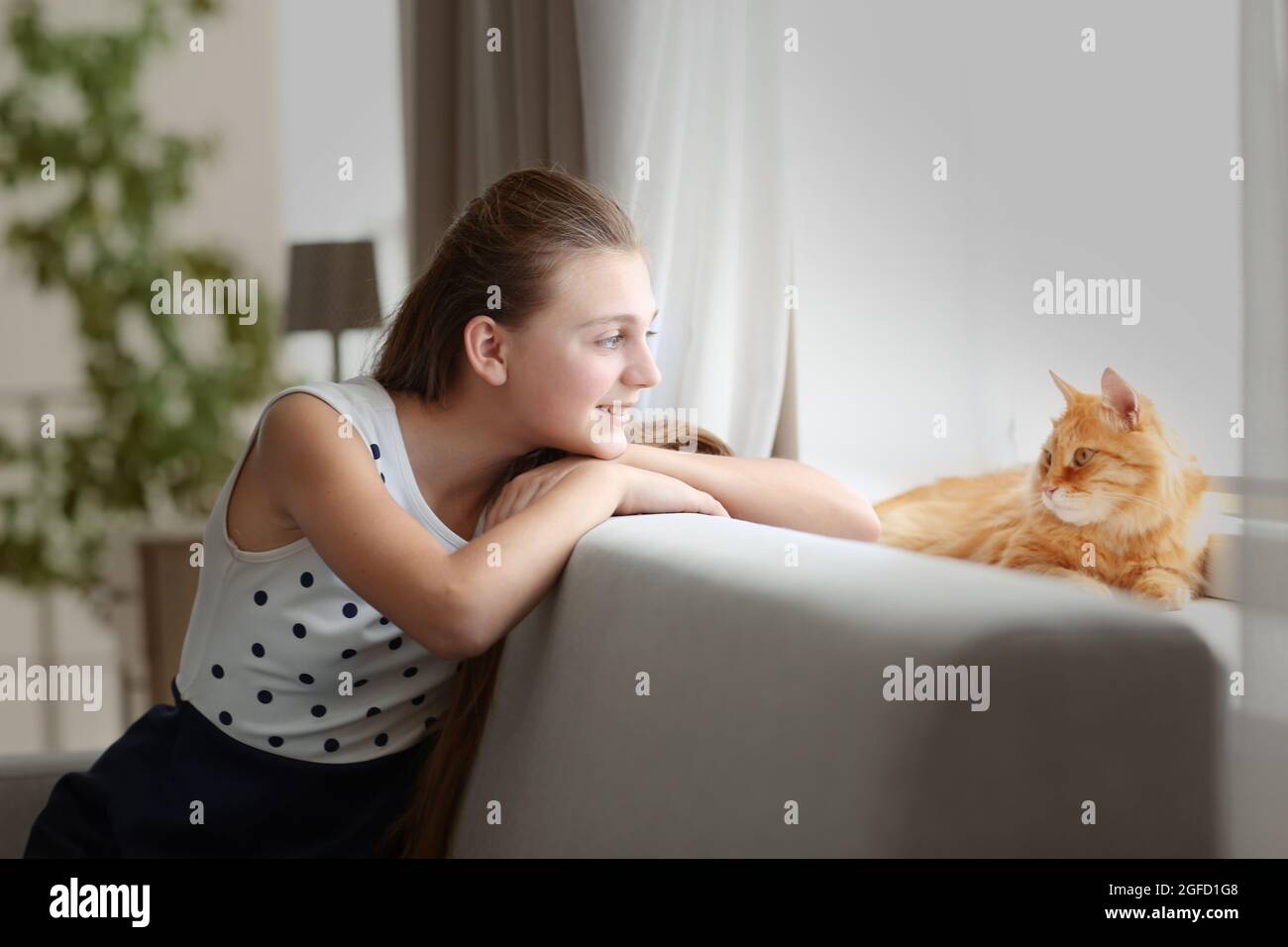 Beautiful girl with cute cat on windowsill Stock Photo - Alamy