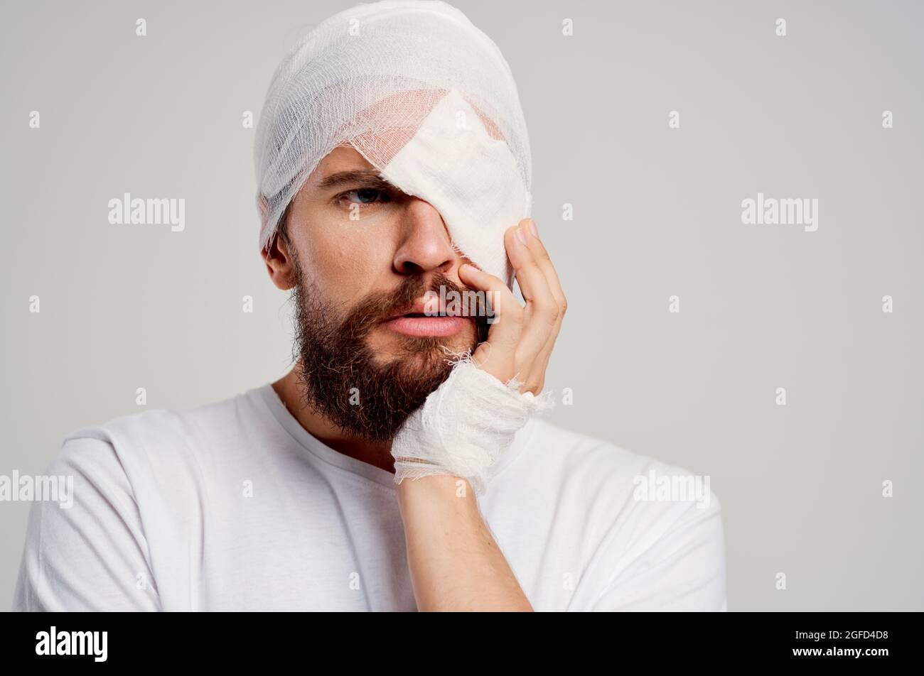 Man with a bandaged head and an eye blood light background Stock Photo ...