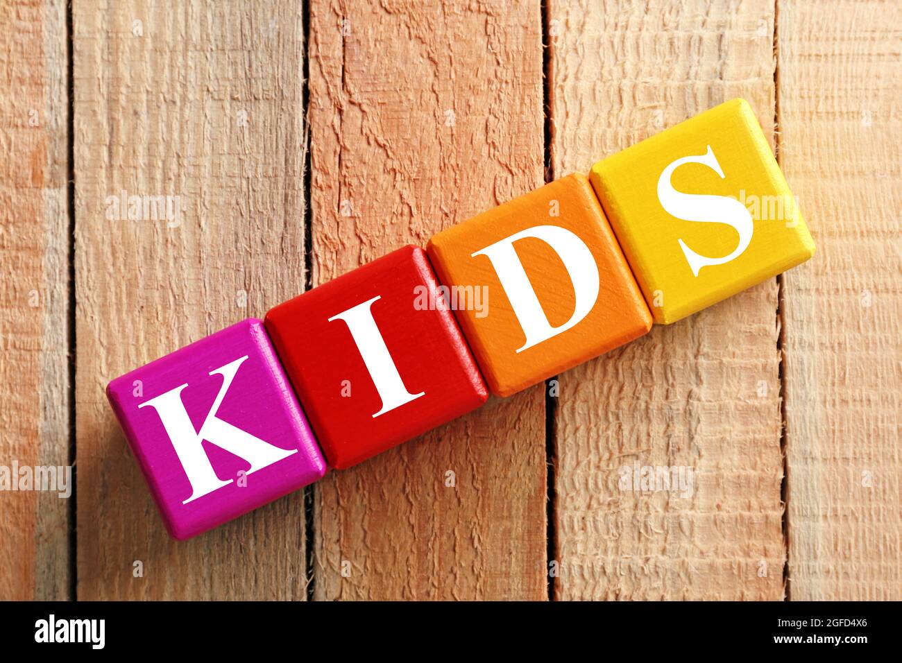 Color word KIDS on wooden background Stock Photo - Alamy