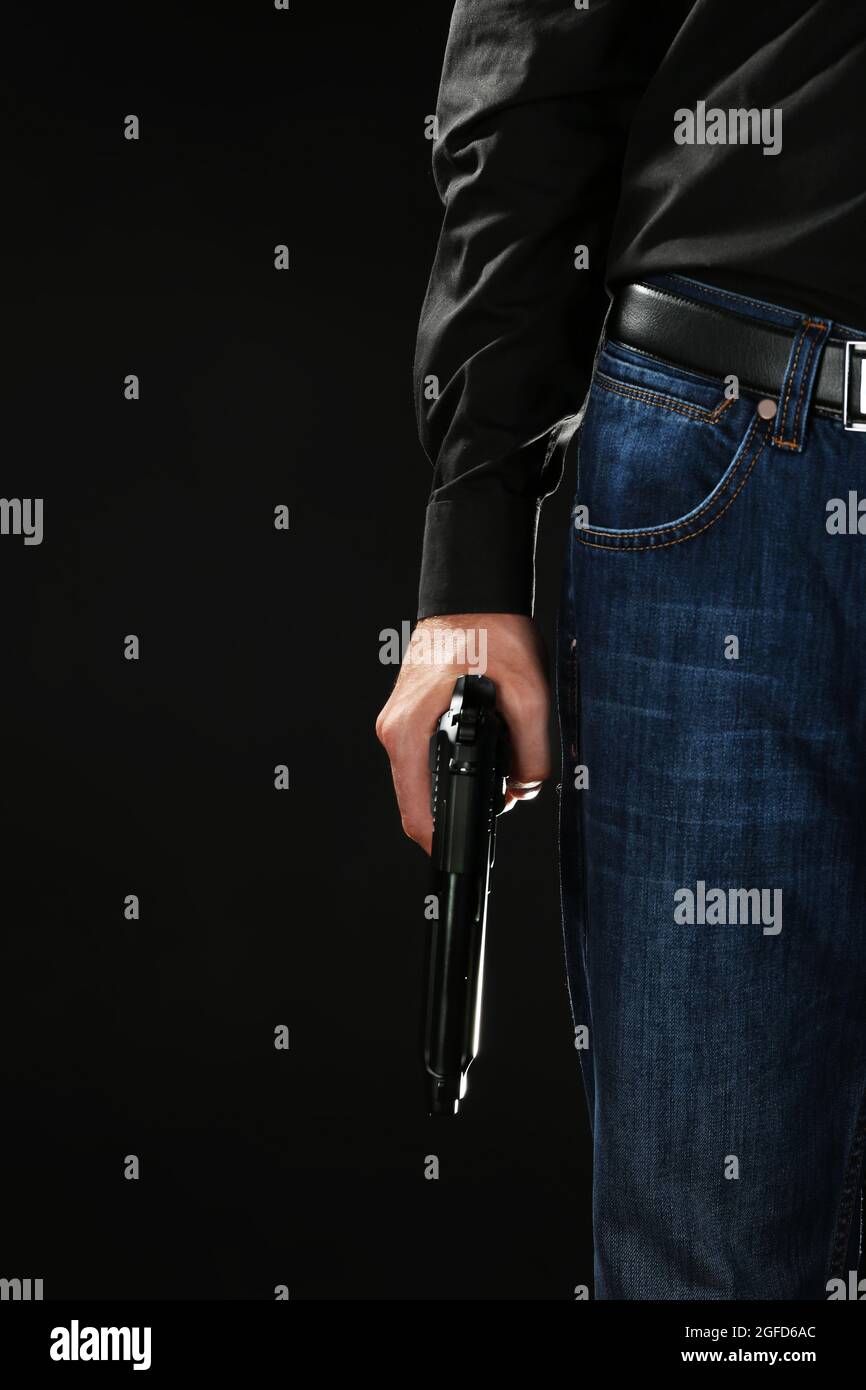 Man with gun on black background, close up Stock Photo - Alamy