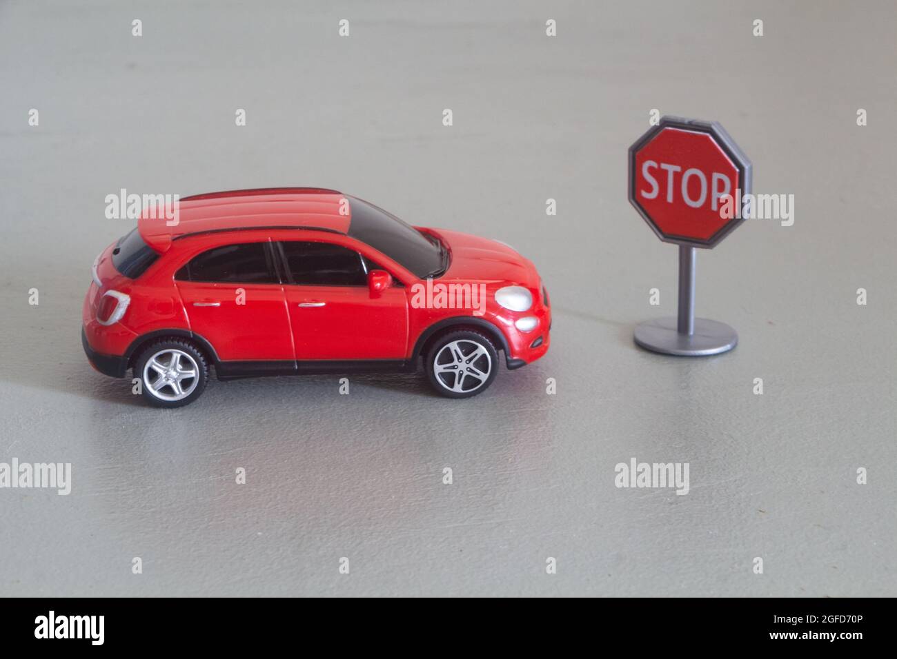 Red toy car and stop roadsign in plastic Stock Photo - Alamy