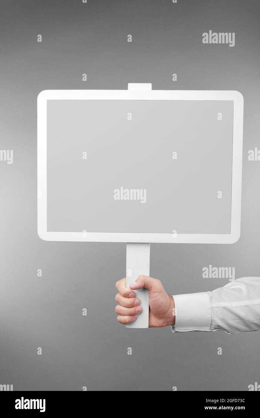 Man's hand holding red sign board on light background Stock Photo - Alamy