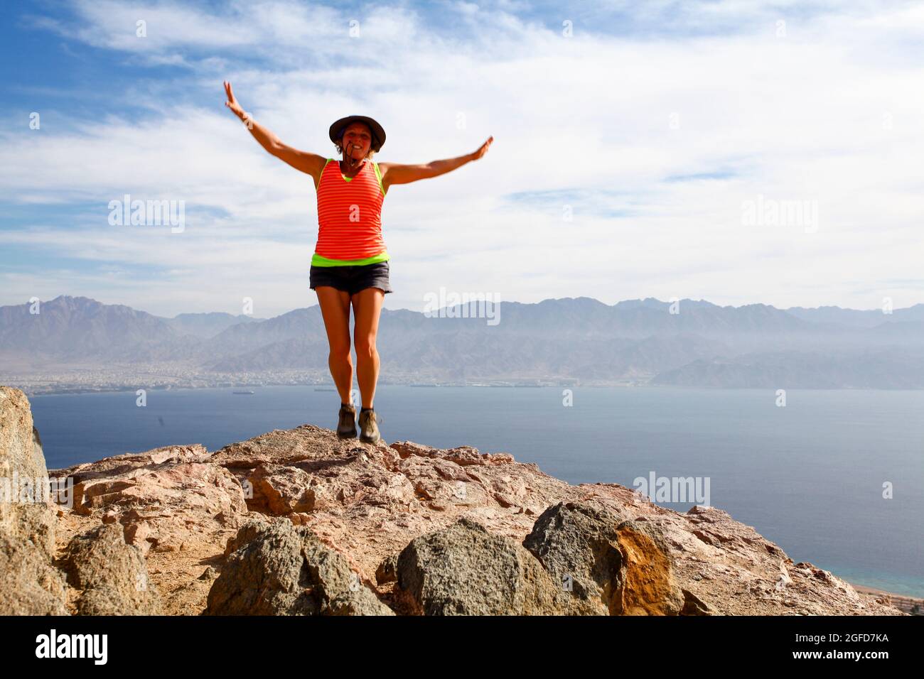 Female hiker celebrates her achievement on reaching the summit of the ...