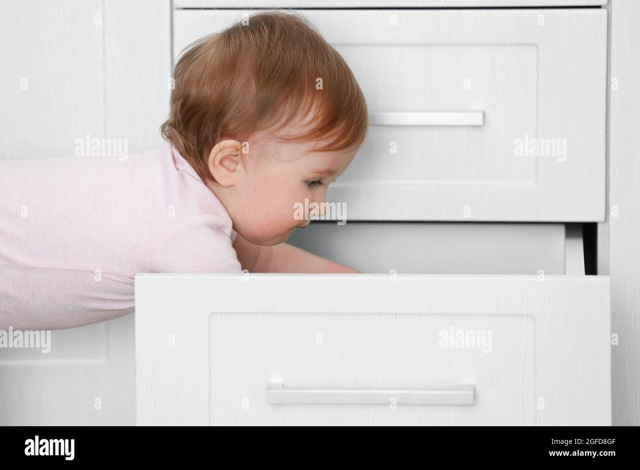 Little child playing with drawer Stock Photo - Alamy