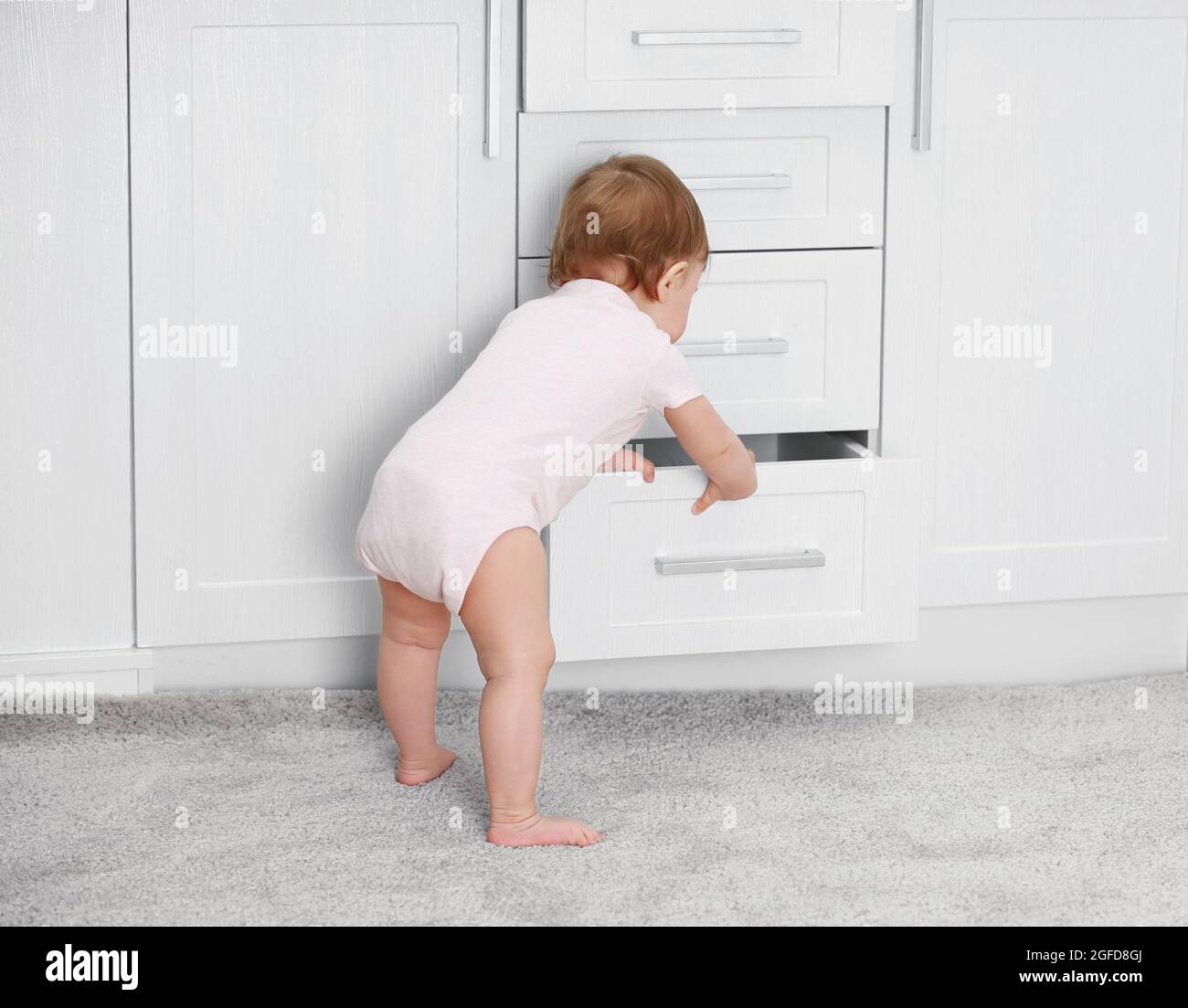 Little child playing with drawer Stock Photo - Alamy
