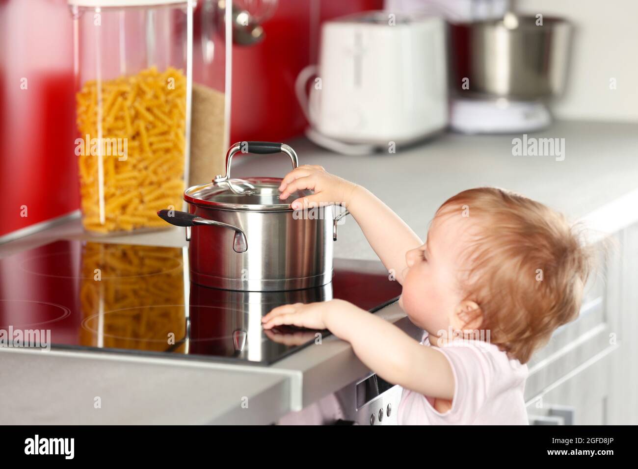 Little child playing with pan and electric stove in the kitchen Stock ...