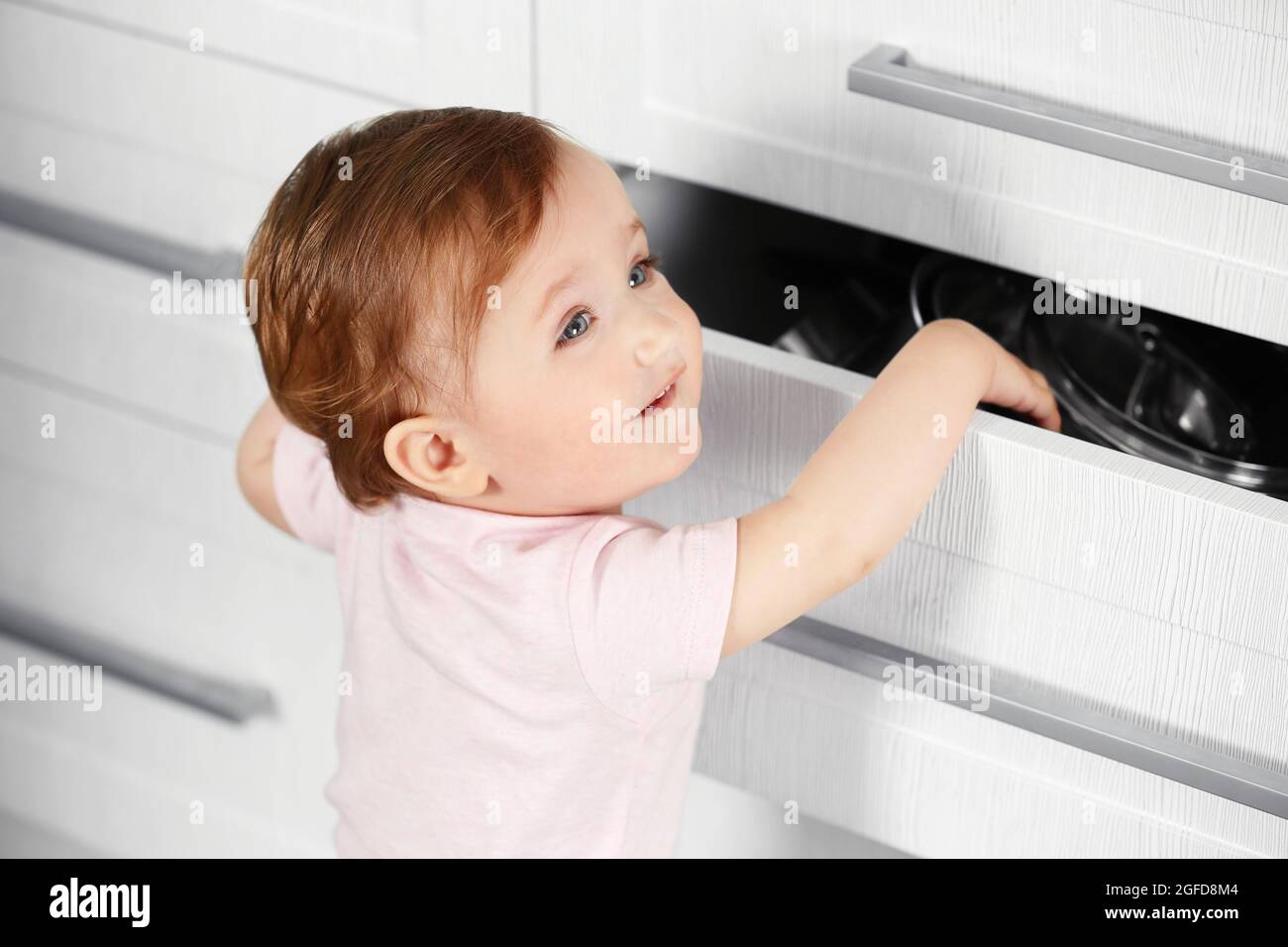 Little child playing with drawer Stock Photo - Alamy