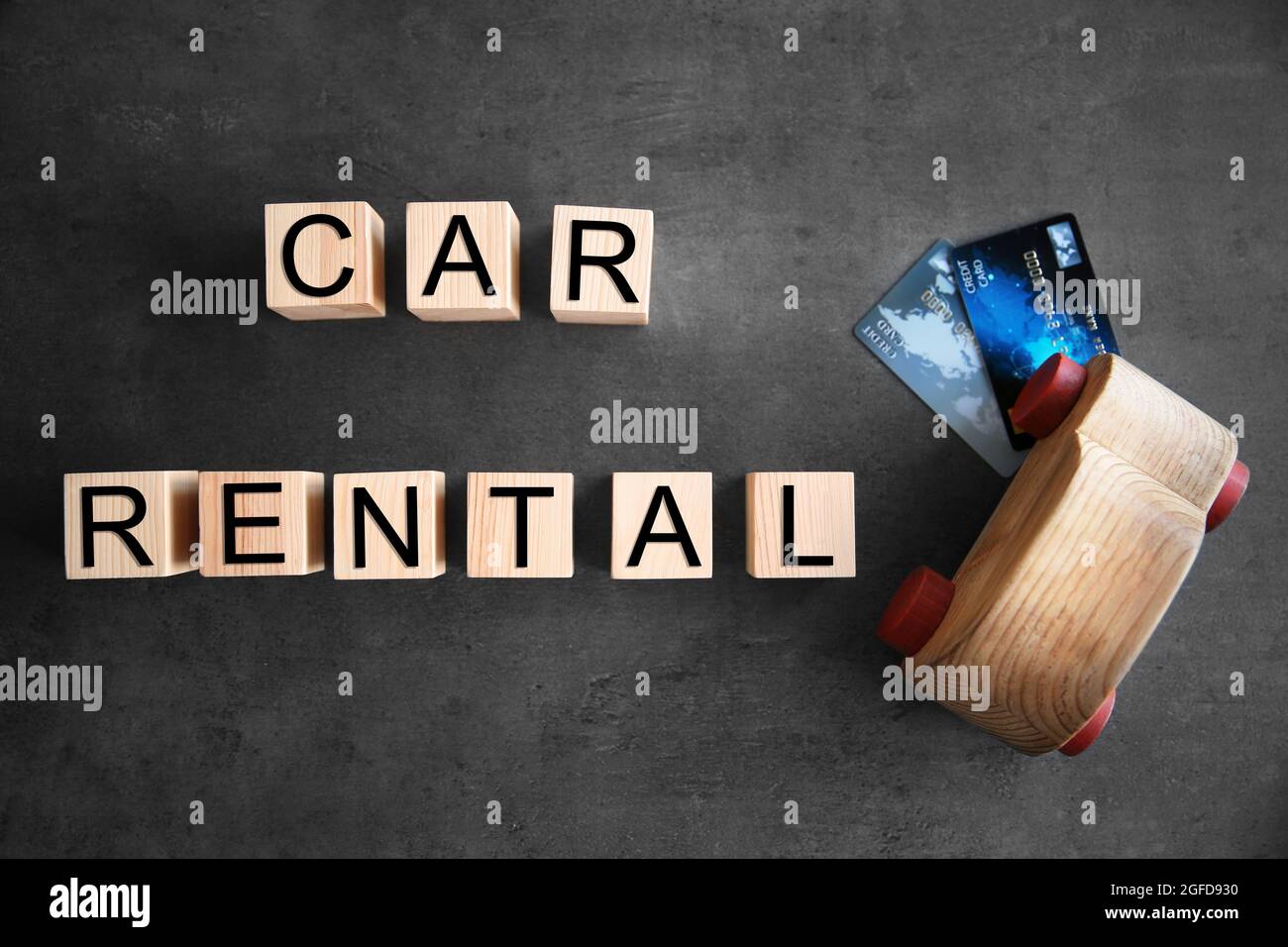 Cubes with words CAR RENTAL and wooden toy on grey background, top view ...