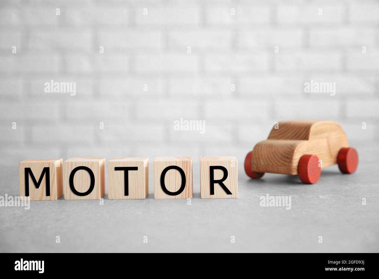 Cubes with word MOTOR and toy car on brick wall background Stock Photo ...