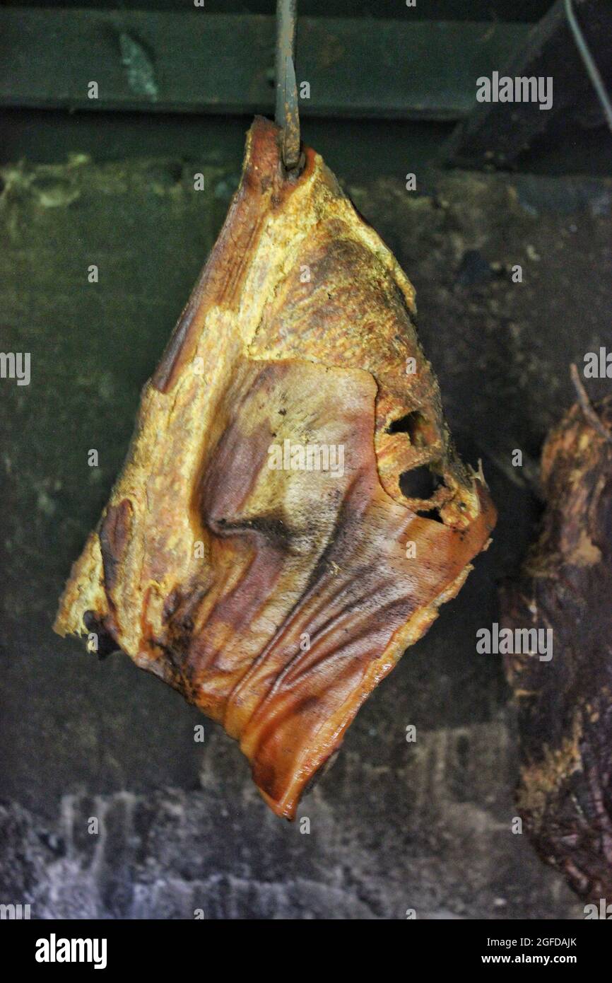 Huge smoked meat hanging in the smokehouse on a beautiful sunny summer ...