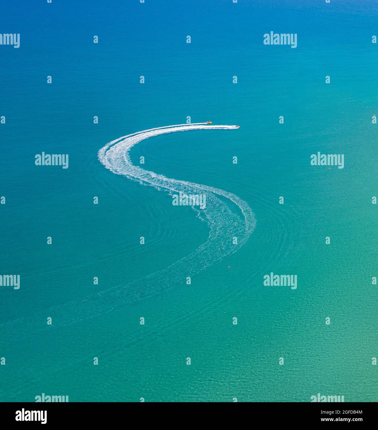 Watersports at the beach. Speedboat and wave slider leaving zigzag ...