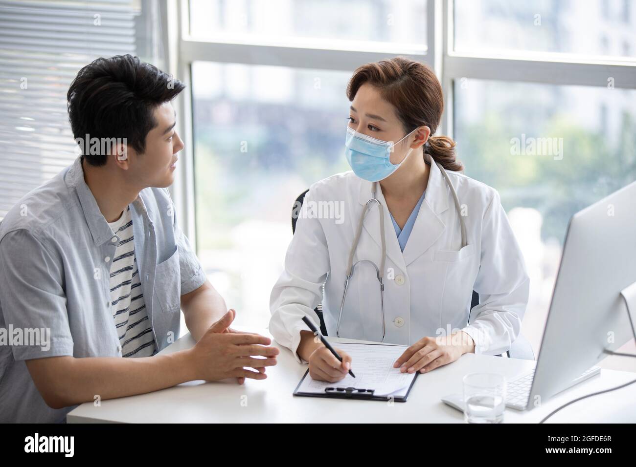 Doctor talking with patient Stock Photo - Alamy