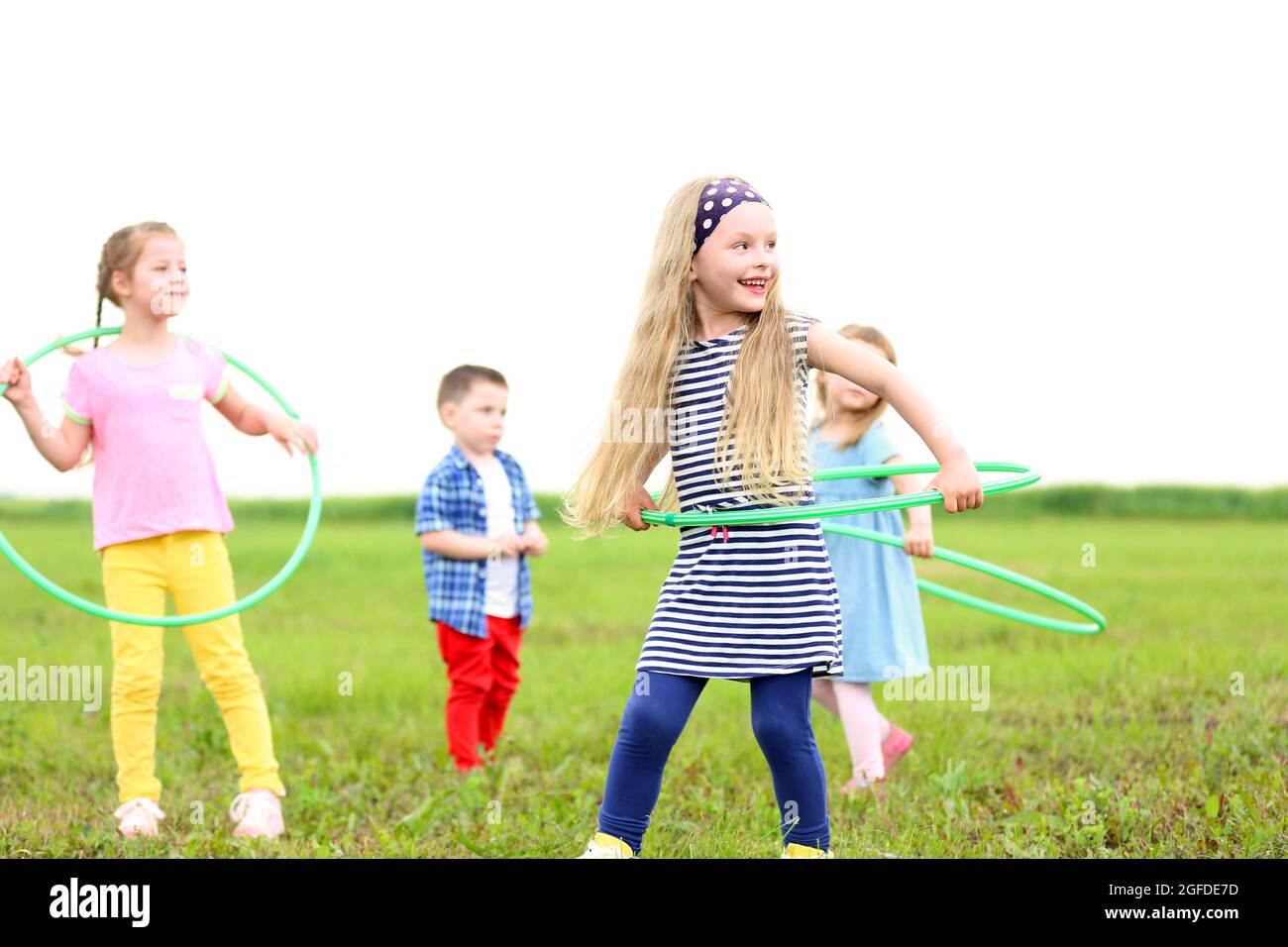 Children having fun with hula hoops outdoor Stock Photo - Alamy