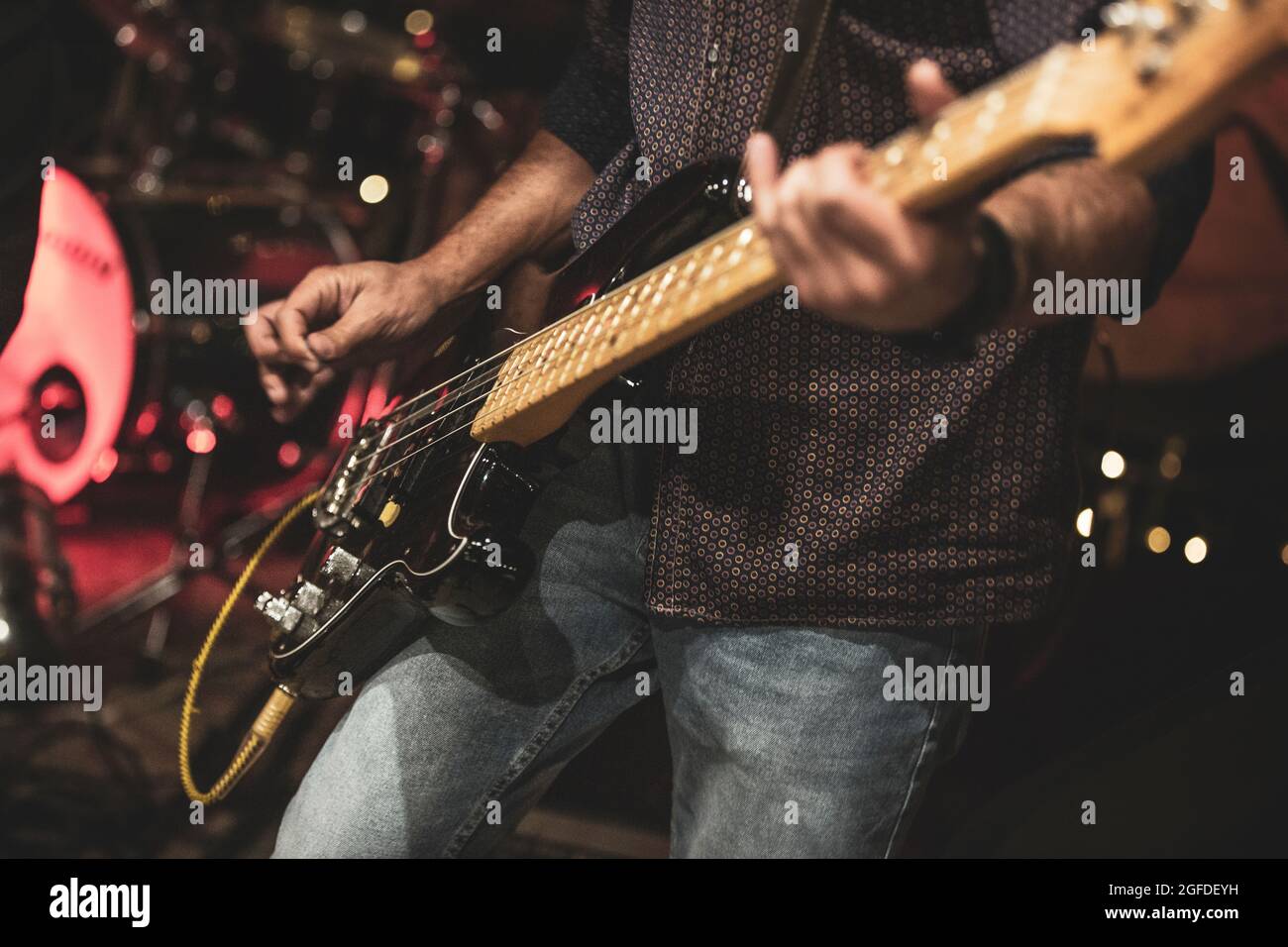 detail of a musician playing the electric bass during a live concert of ...