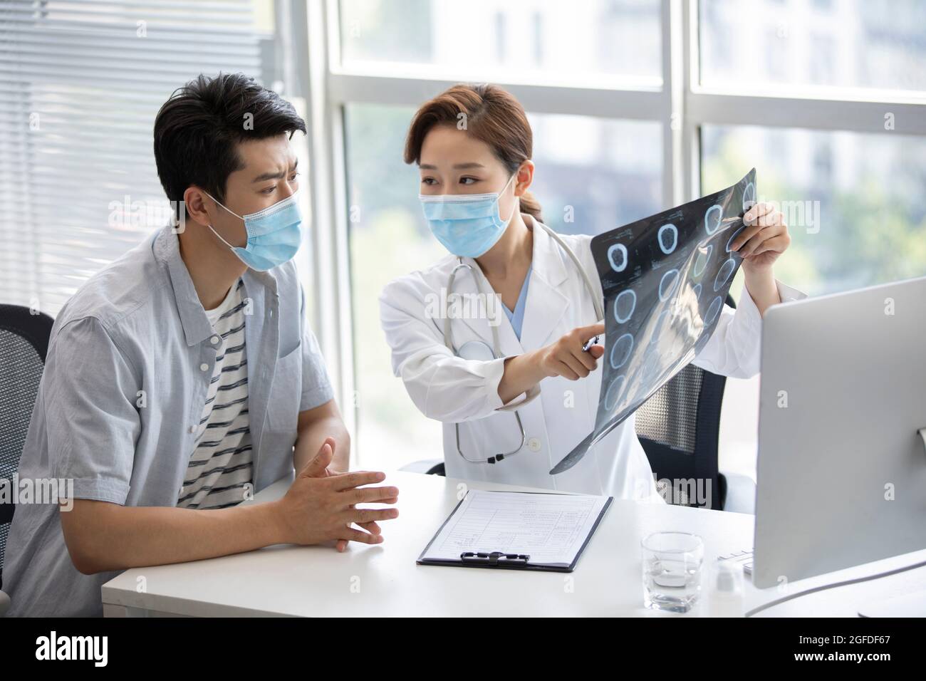 Doctor discussing X-ray image with patient Stock Photo - Alamy