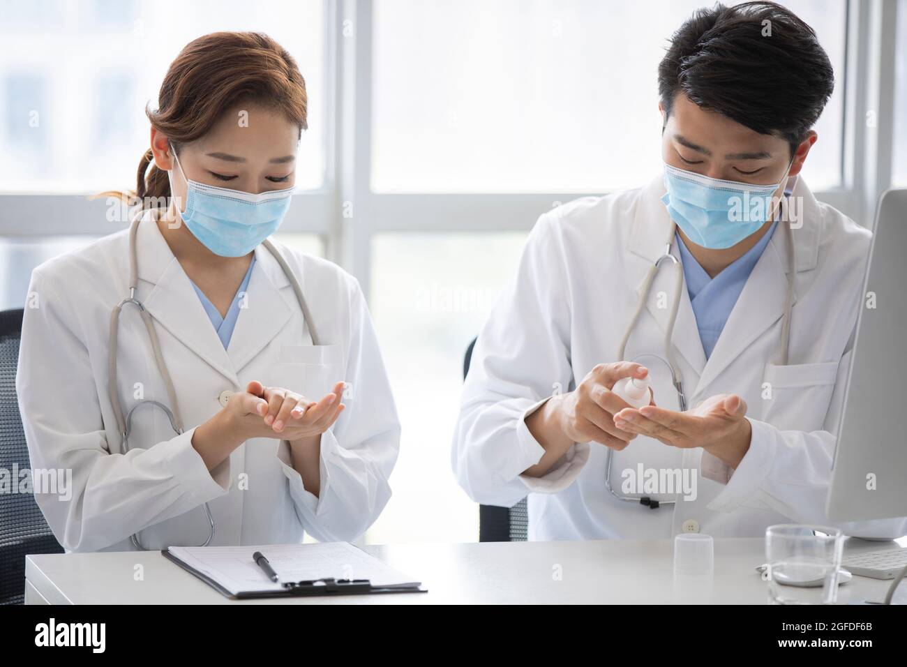 Young doctors using hand sanitizer in doctor's office Stock Photo - Alamy